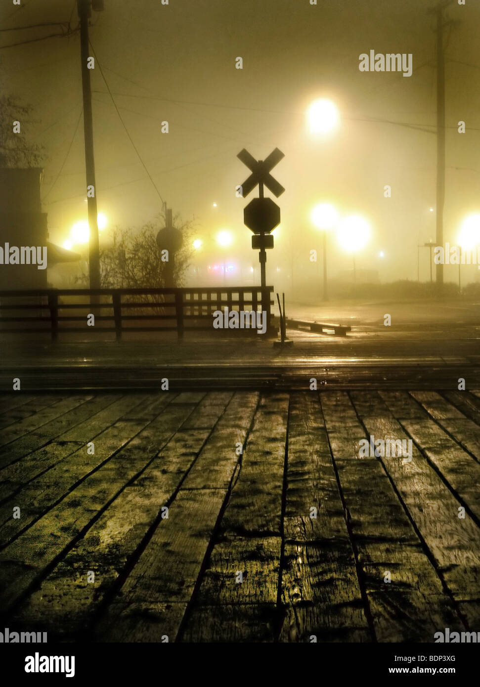 Fog at a rail crossing with street lights in the distance Stock Photo ...