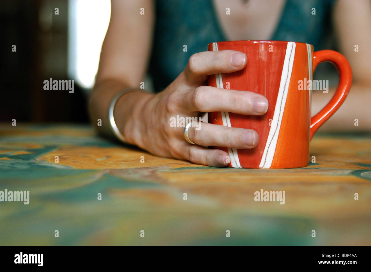 A hand holding a red mug Stock Photo - Alamy