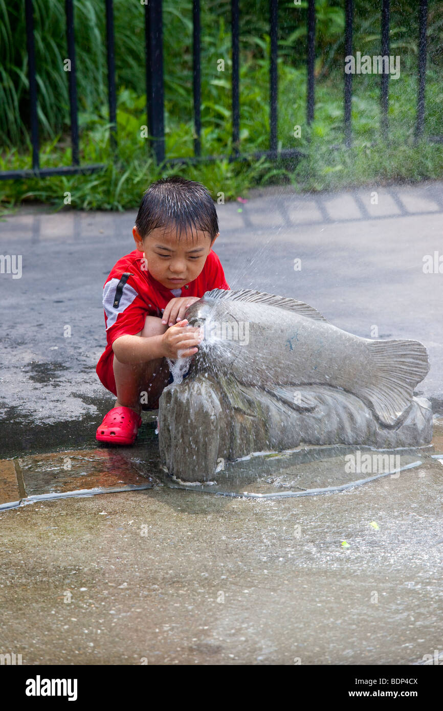 Chinese boy playing in a fountain in a park in the Bronx in New York ...