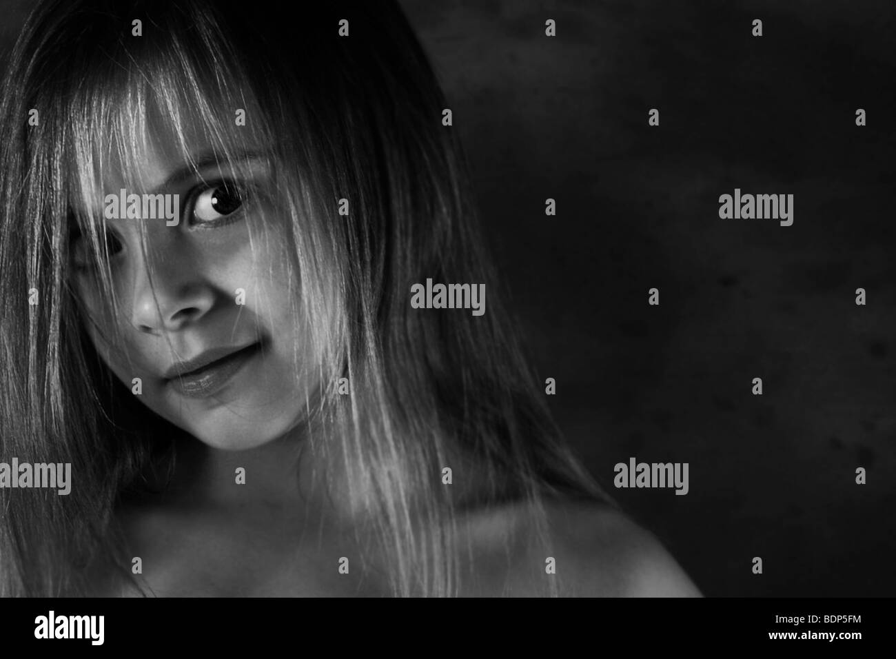 Young child looking at the camera with light shining on her face Stock ...