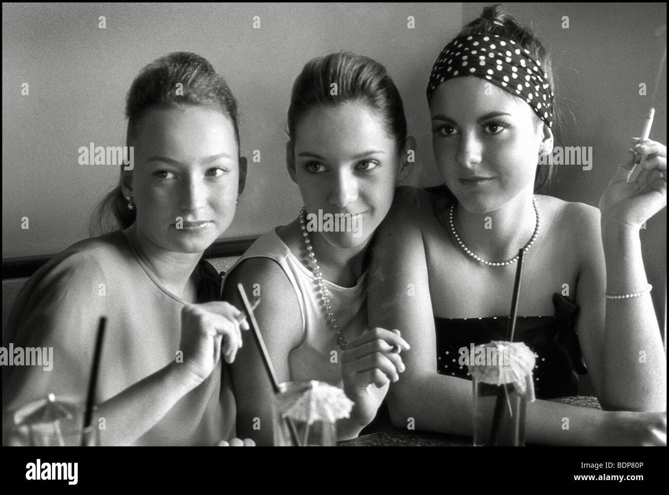 Three teenage girls sitting together and smoking Stock Photo - Alamy