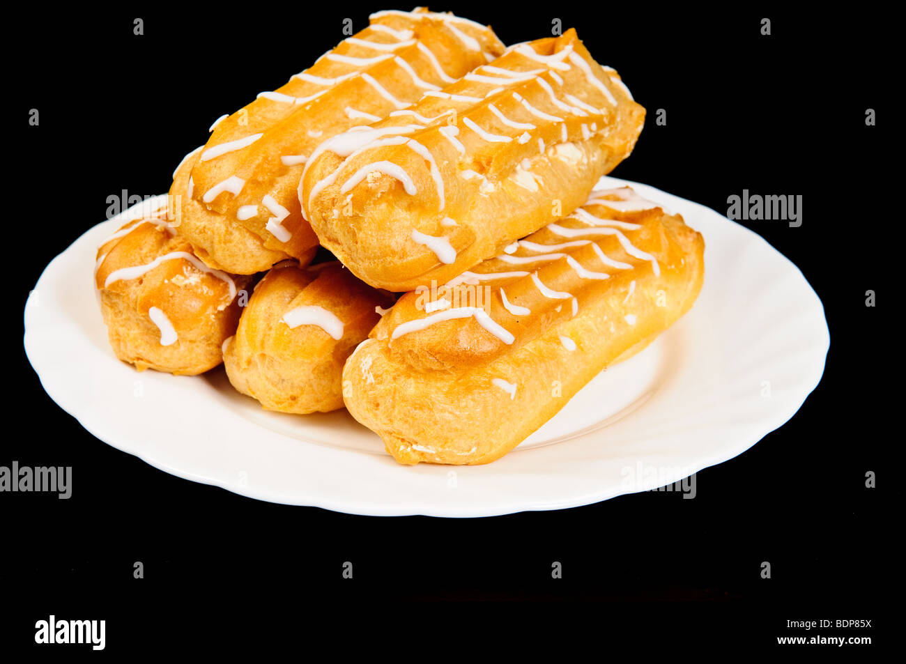 Cream eclairs isolated on a black background Stock Photo - Alamy