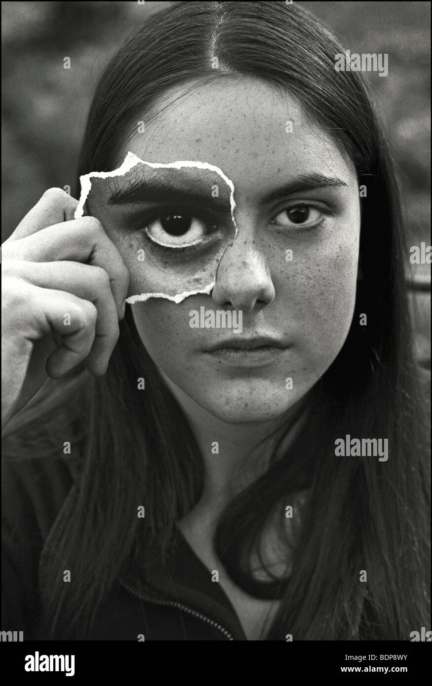 A young woman holding a picture of her eye infront of her face Stock ...