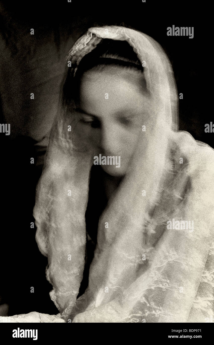 A young woman covering her head with a veil Stock Photo - Alamy