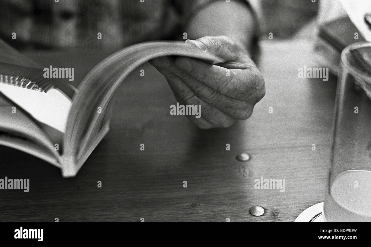 A old persons hand holding a book Stock Photo - Alamy