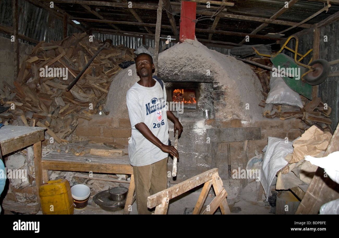 Baker baking bread using wood-fired oven Banjul Gambia West Africa ...