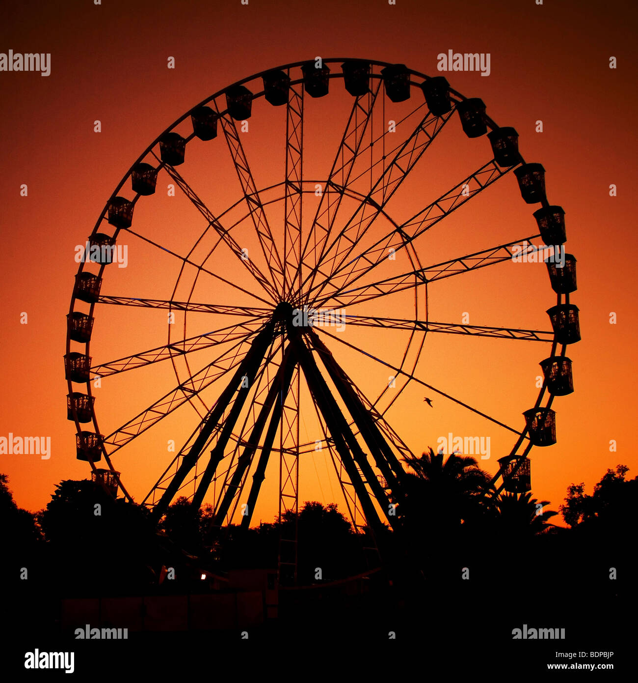 A bill wheel silhouetted against an orange sunset Stock Photo - Alamy