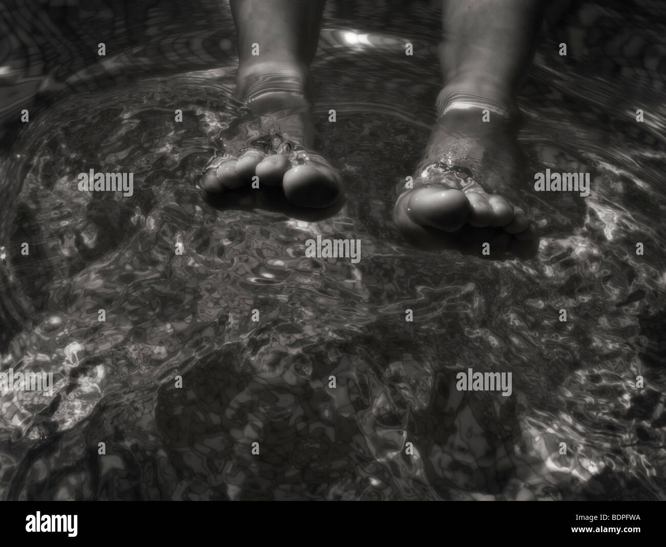 Feet floating in a pool with ripples Stock Photo - Alamy