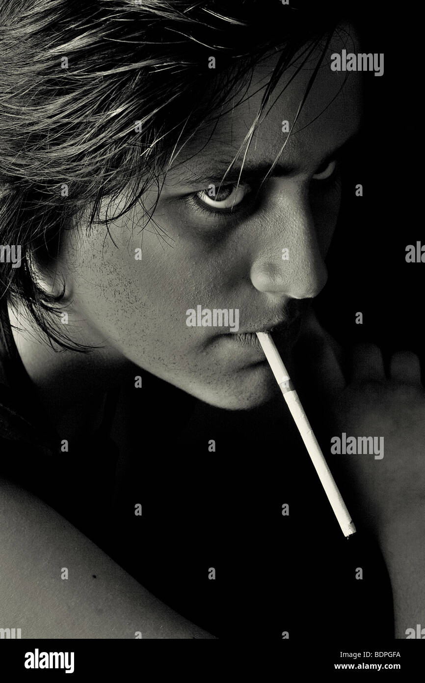 The face of a young man smoking a long cigarette Stock Photo - Alamy