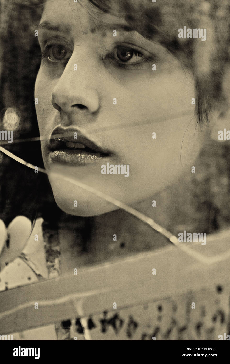 The reflection of a young womans face in a broken mirror Stock Photo ...