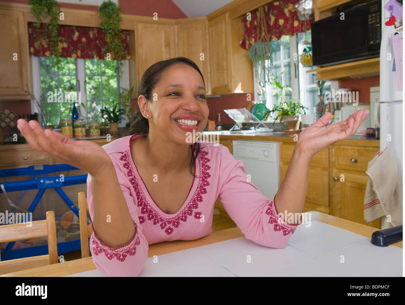 Hispanic woman smiling at a dining table Stock Photo - Alamy