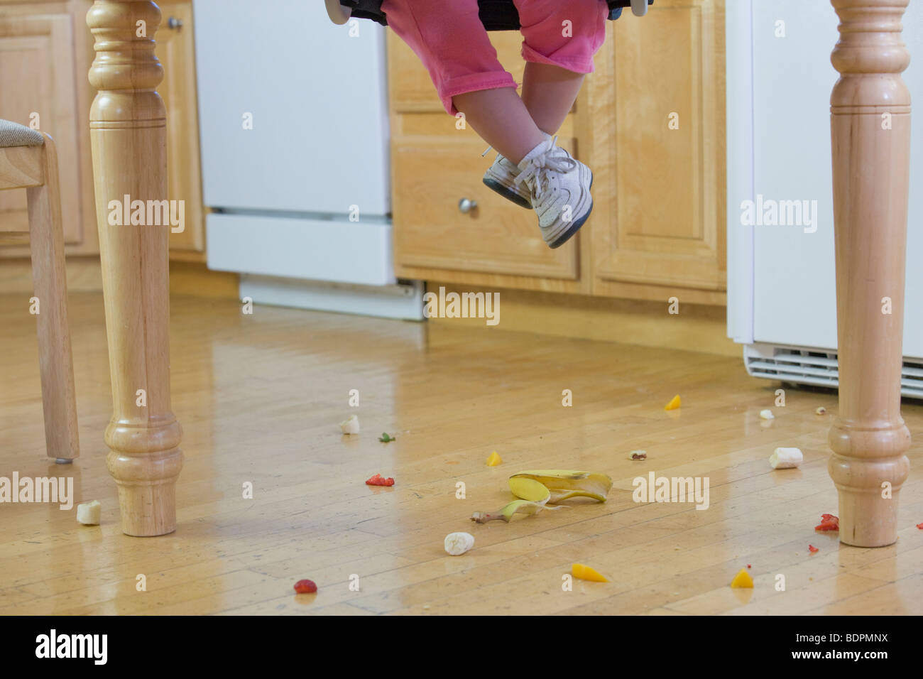 Low section view of a baby girl with spilled food on the floor Stock ...