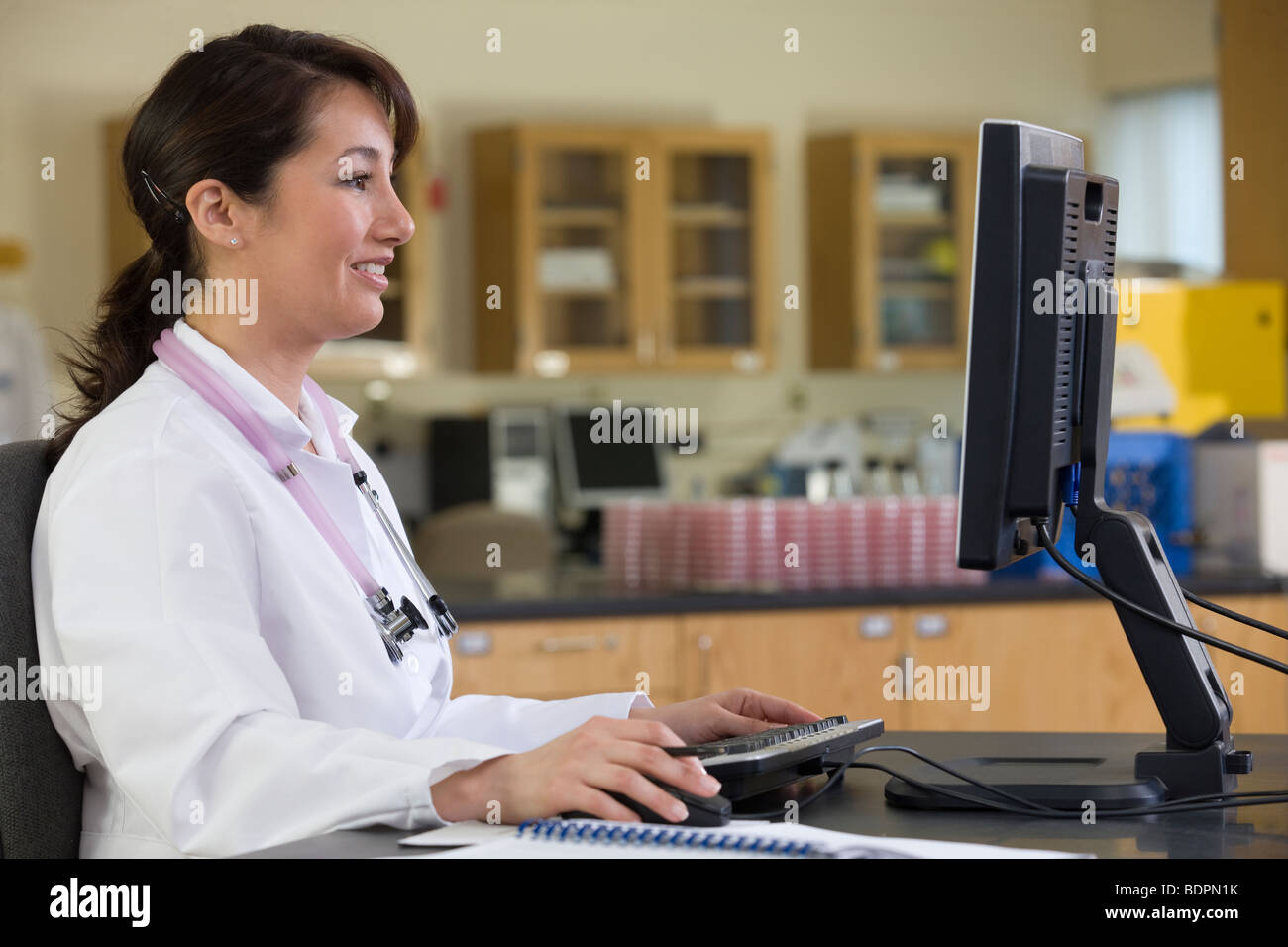 Female lab technician working on a computer Stock Photo - Alamy