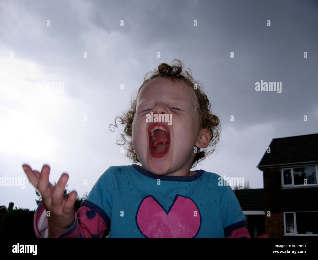 Toddler catching rain in her mouth Stock Photo - Alamy