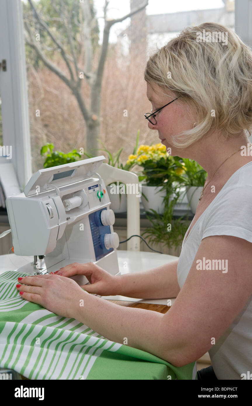 Woman using a sewing machine Stock Photo - Alamy