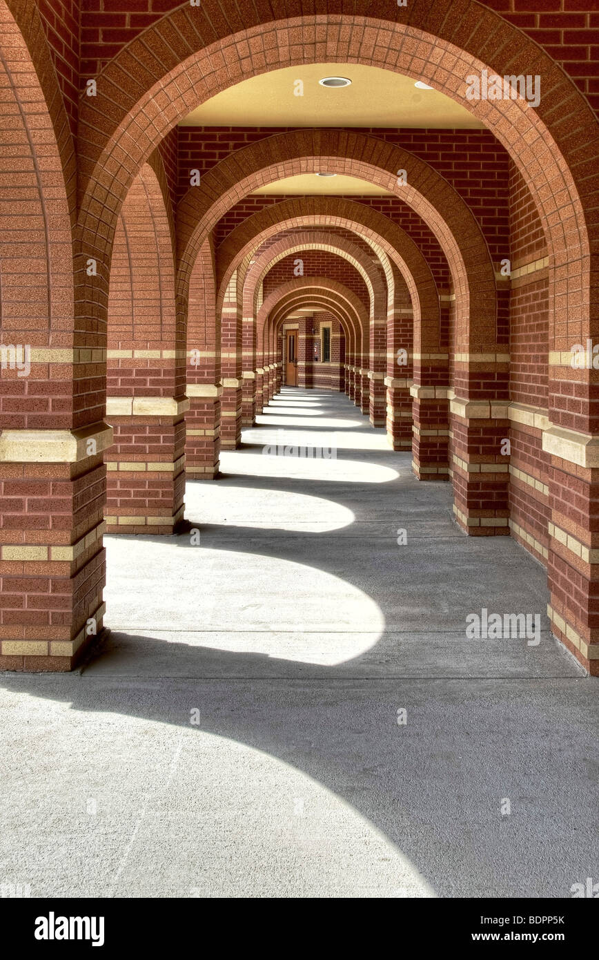 Looking along a line of brick archways with sunlight and shade Stock ...