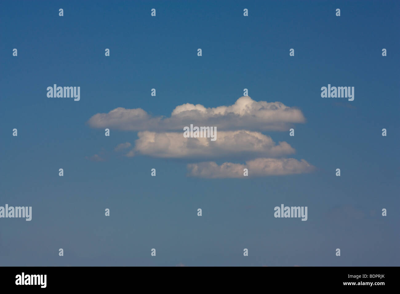 Three clouds in a sky Stock Photo - Alamy