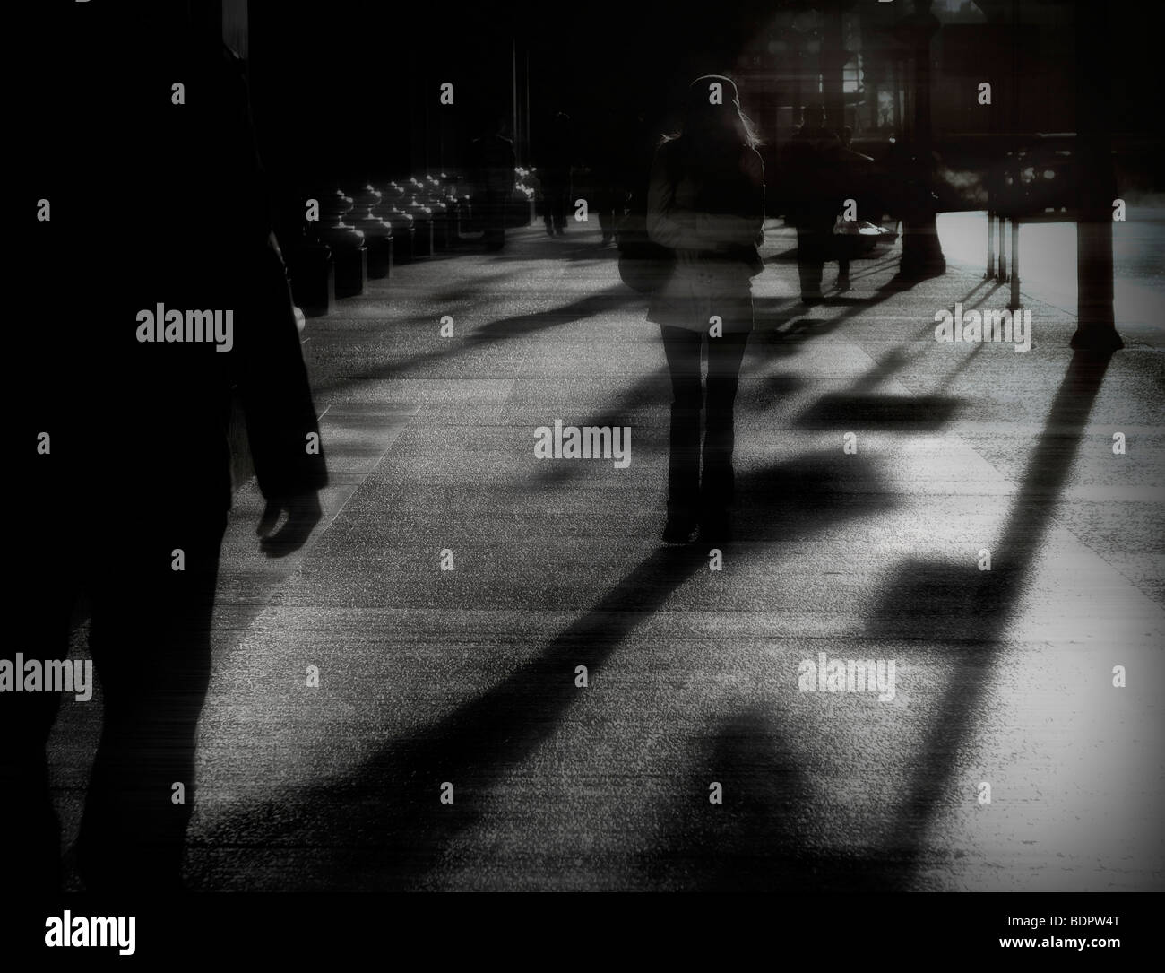 Silhouetted figures walking along a street Stock Photo - Alamy