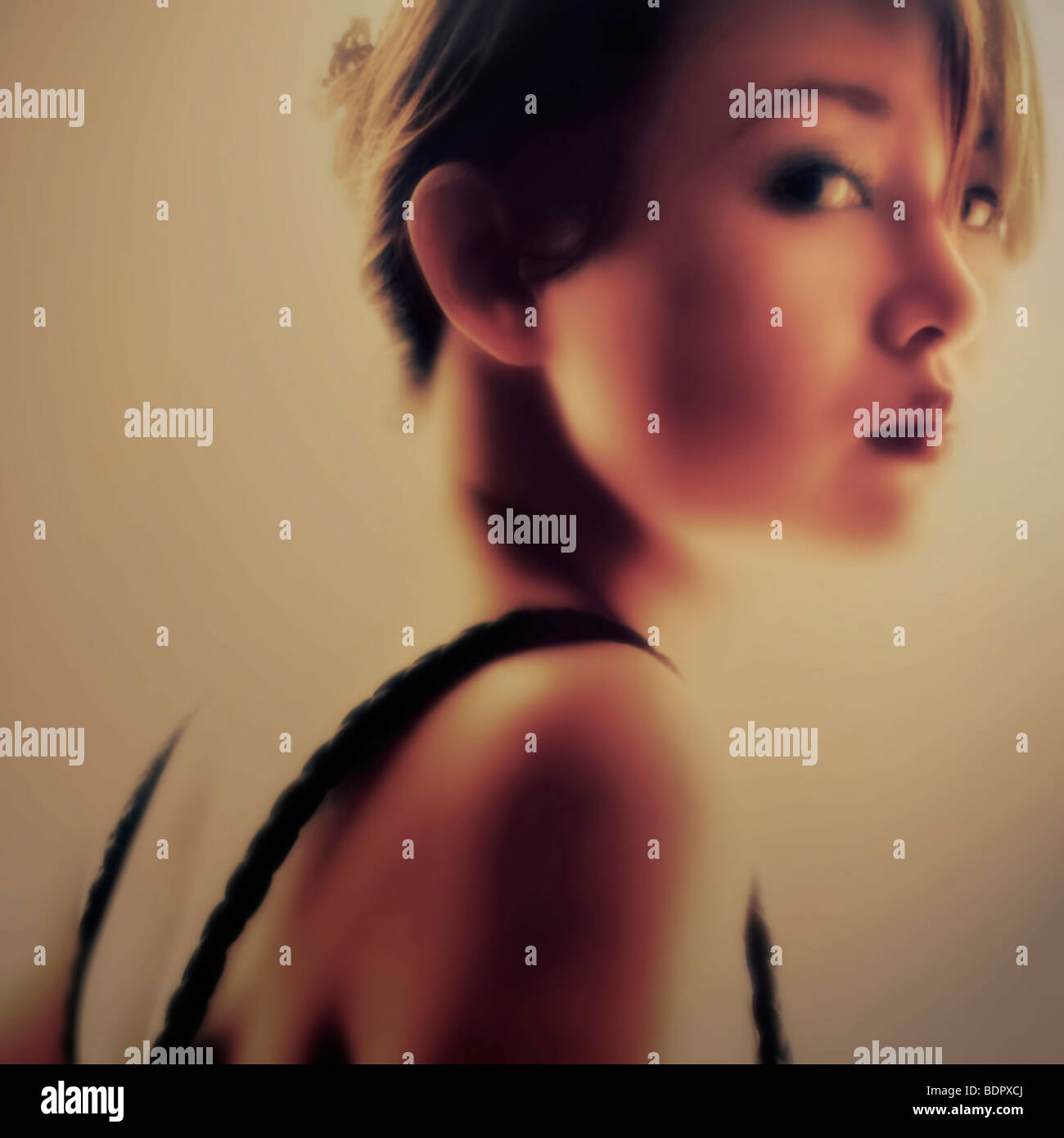 A young woman looking back over her shoulder Stock Photo - Alamy