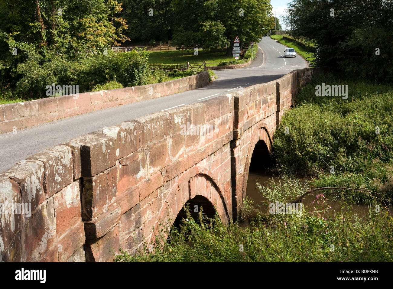 UK, England, Cheshire, Aldford, car crossing bridge over River Dee at ...