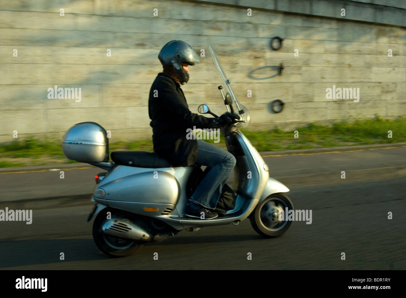 Man riding motor scooter Stock Photo - Alamy