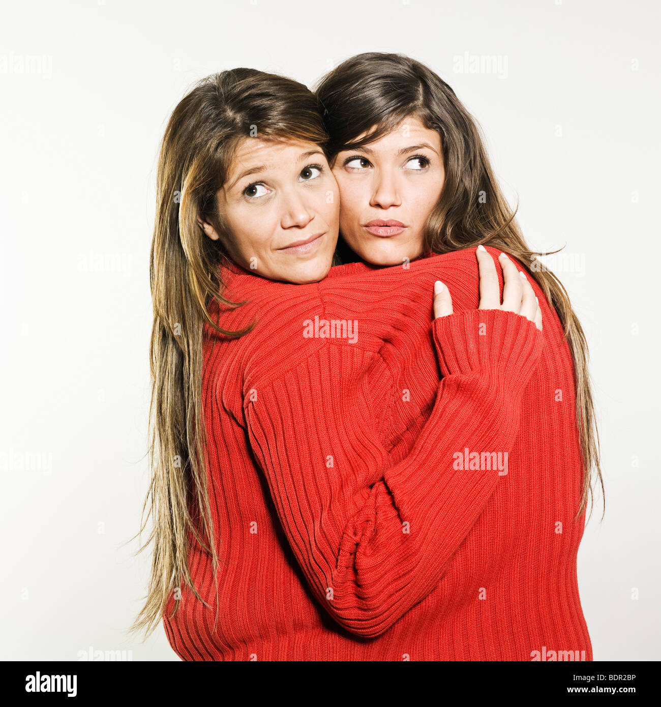 studio shot portrait on isolated background of two sisters twin women ...