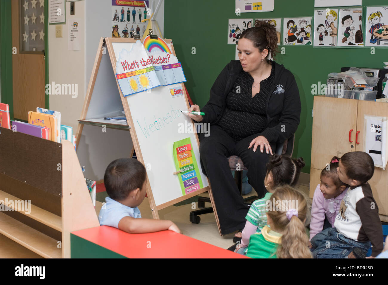 Preschool teacher showing her students the days of the week Stock Photo ...