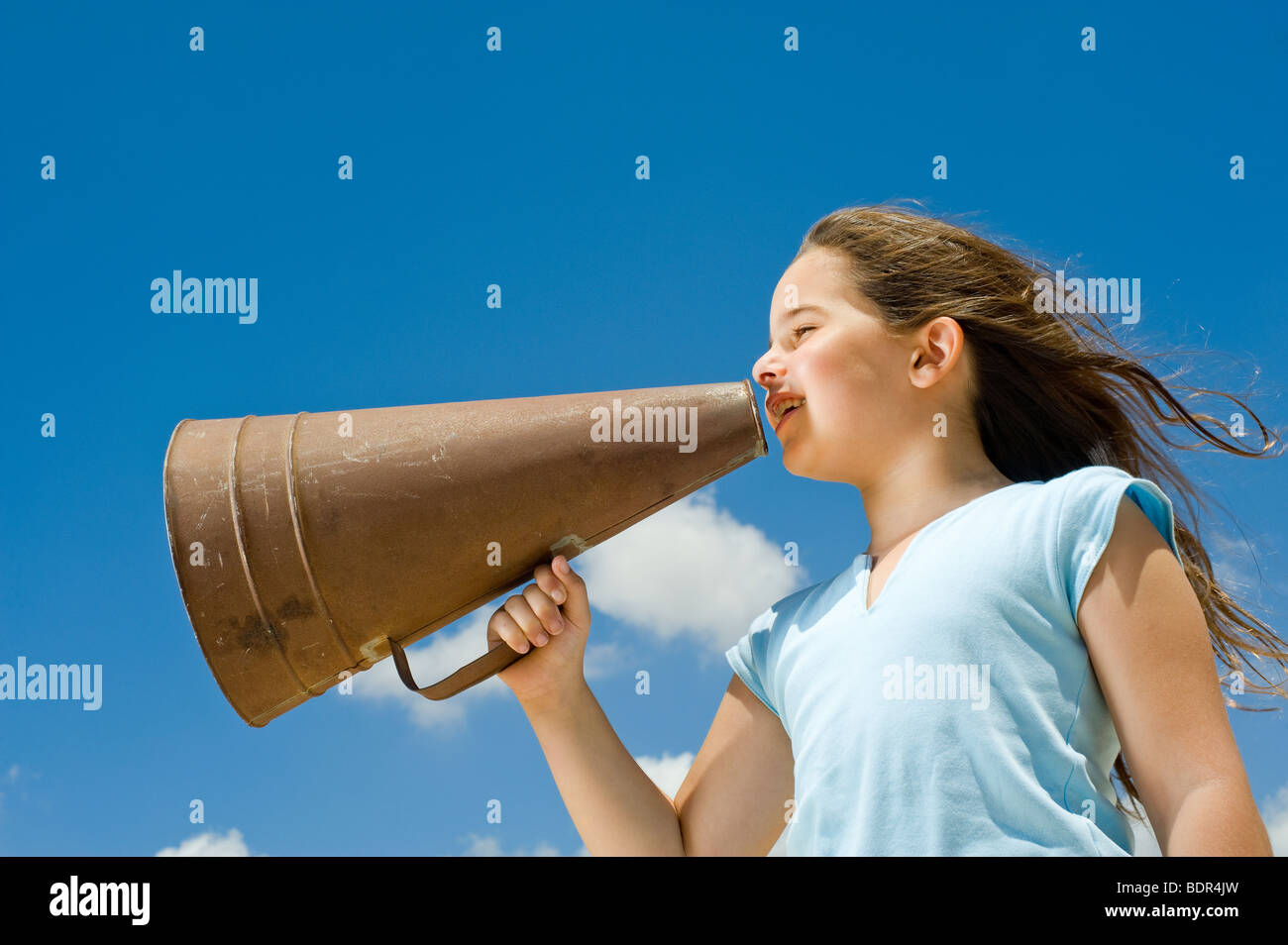 girl shouting with a megaphone against blue sky Stock Photo - Alamy