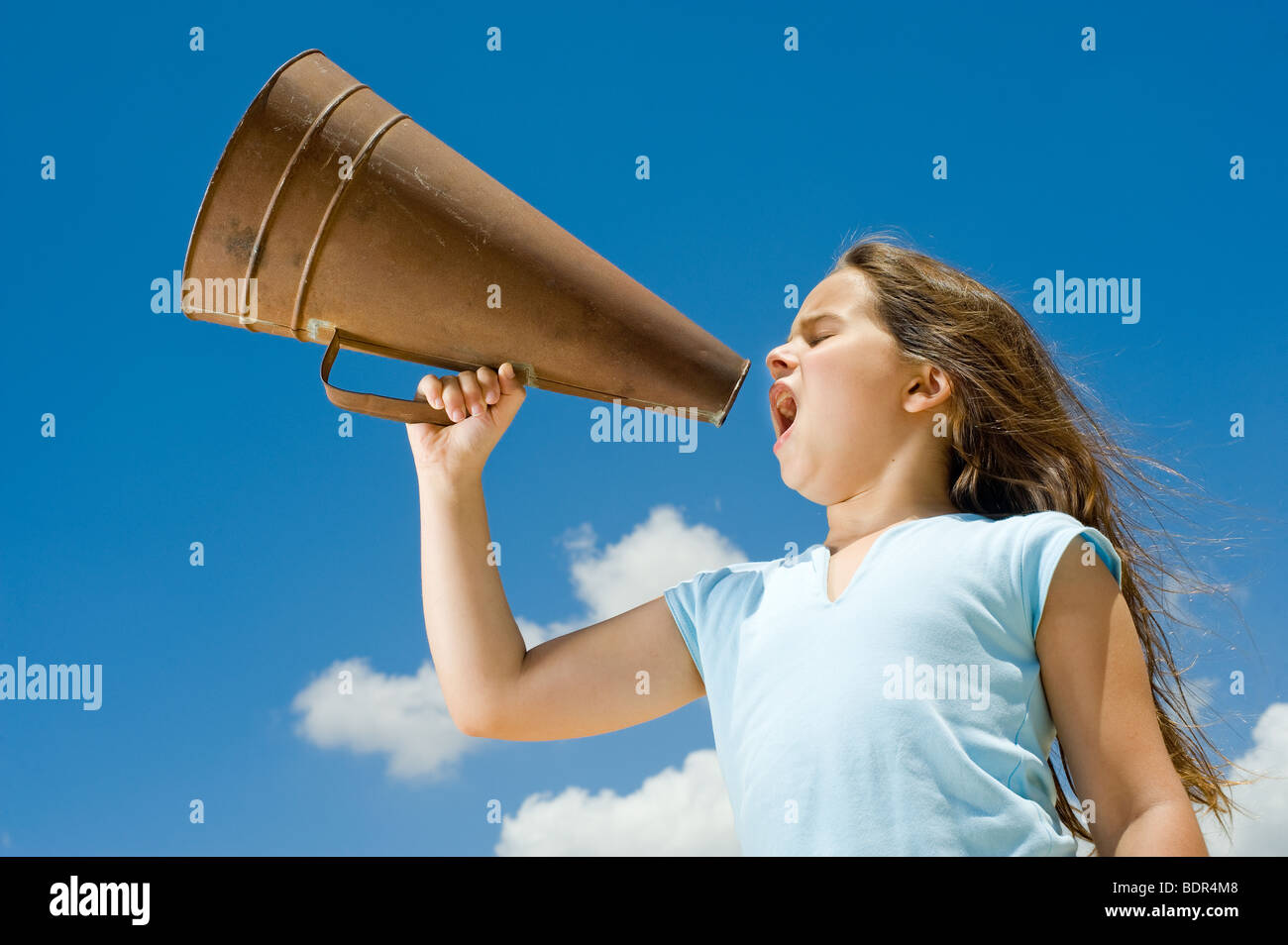 girl shouting with a megaphone against blue sky Stock Photo - Alamy