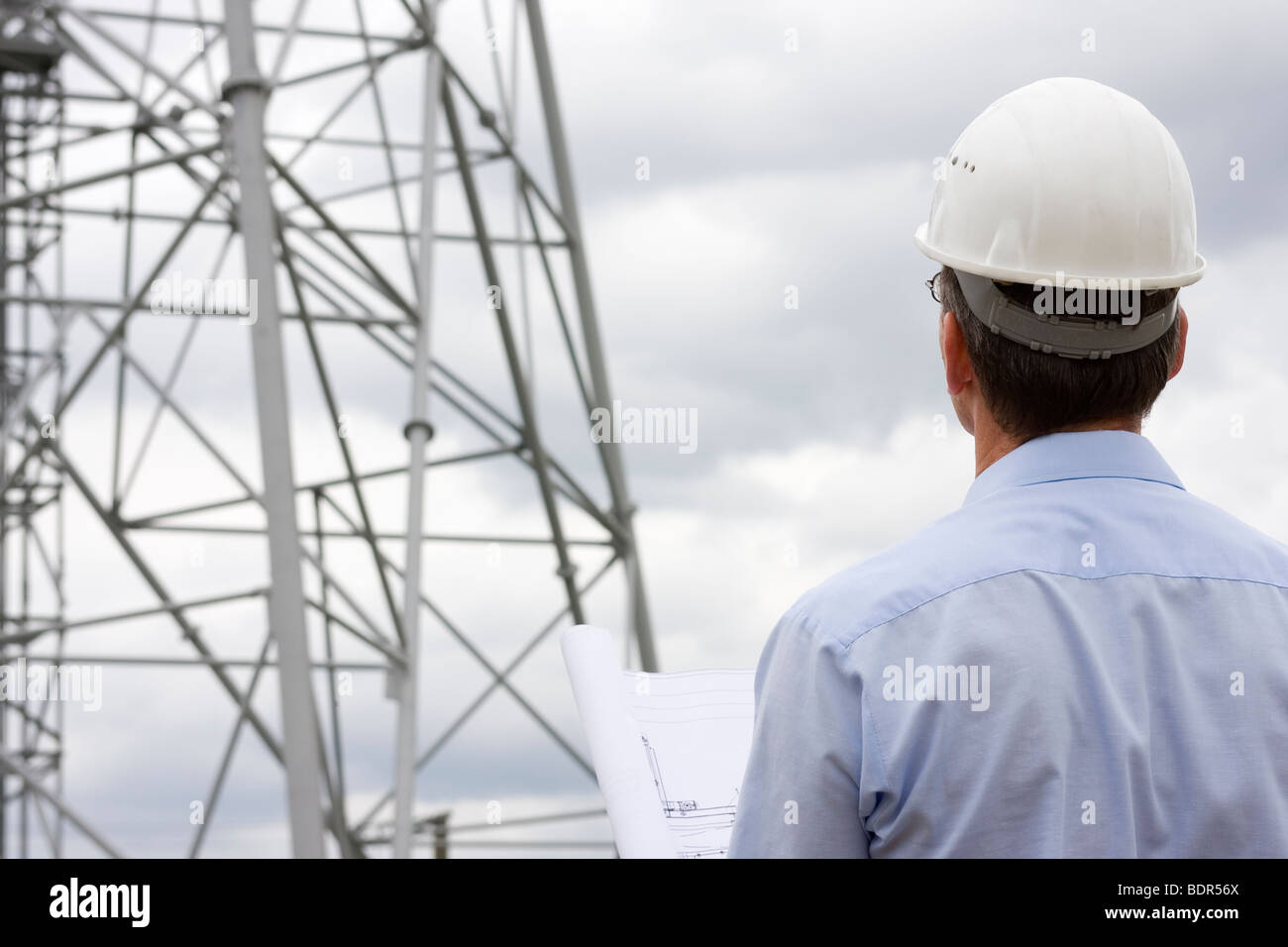 Engineer looking at construction side with plan in his hand Stock Photo ...