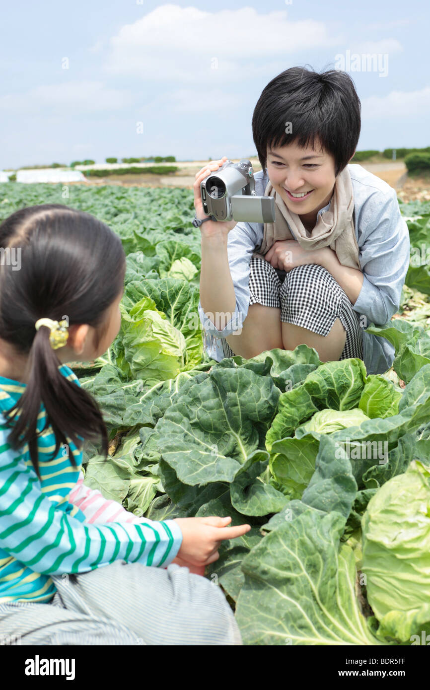 Mother shooting daughter in cabbage field Stock Photo - Alamy