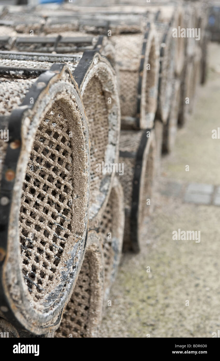 Prawn pots stacked in neat rows on harbour dockside in seaside town ...