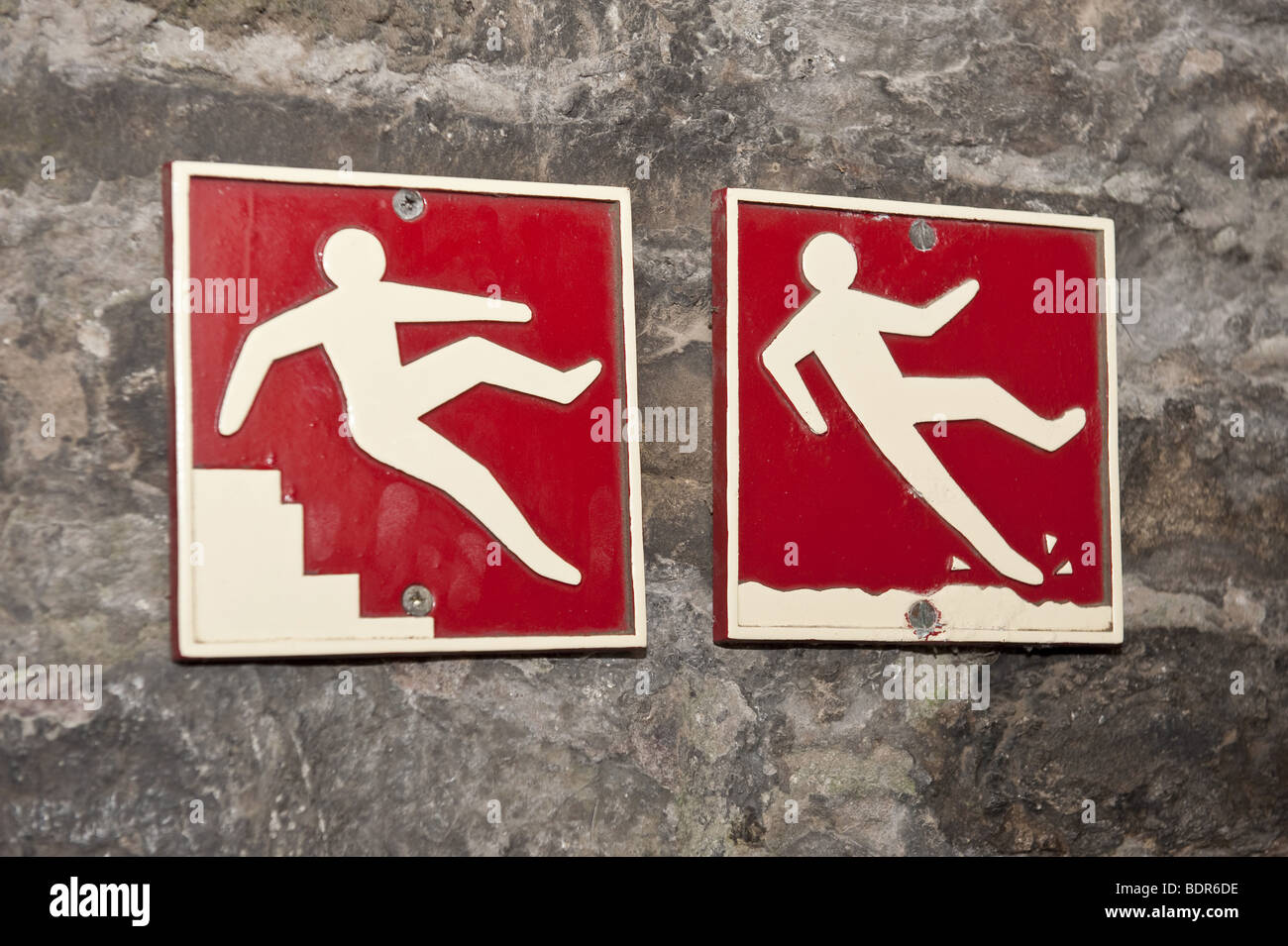 Unusual wall hung red warning signs indicating tripping dangers of an ...