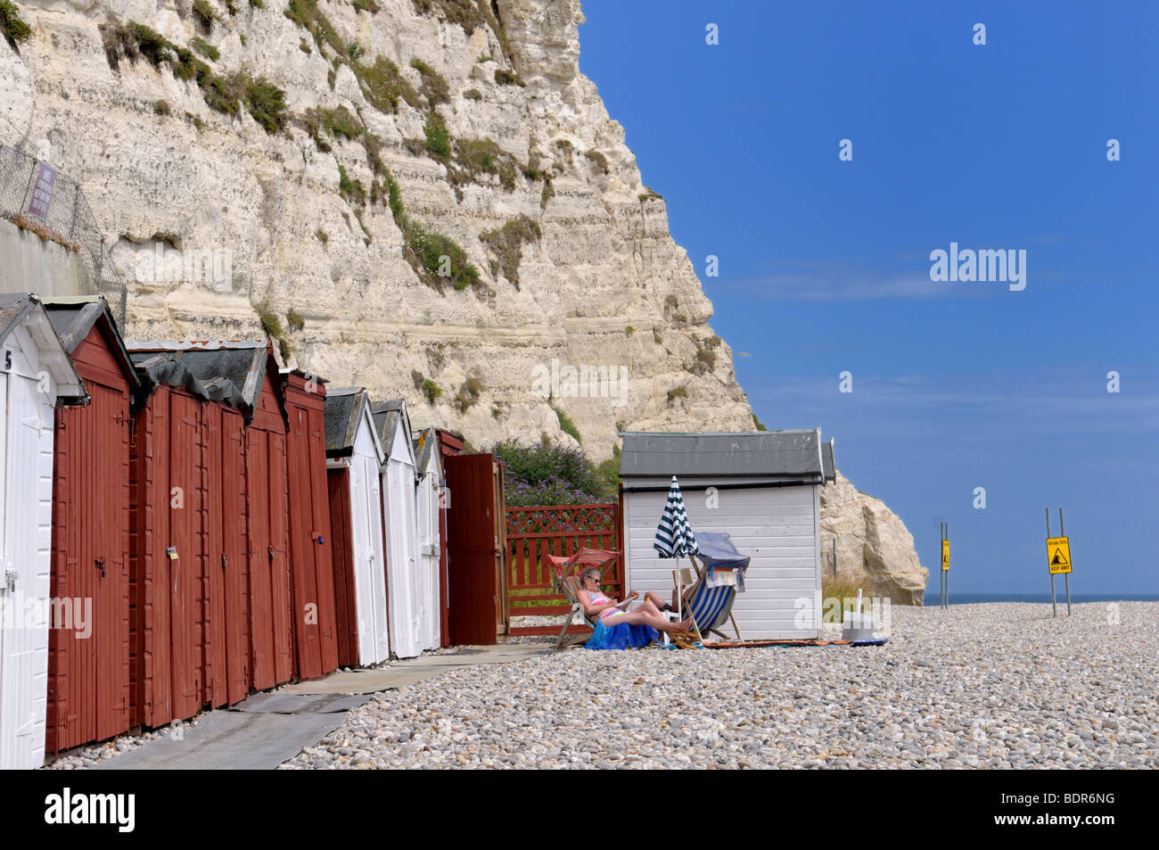 Beach huts and white cliffs on the Jurassic Coast at Beer Devon England ...