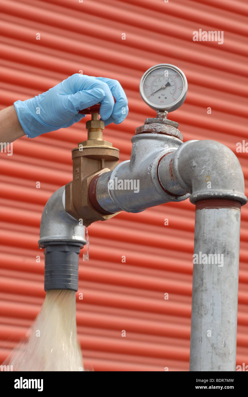 Workman turning on a main water supply Stock Photo - Alamy