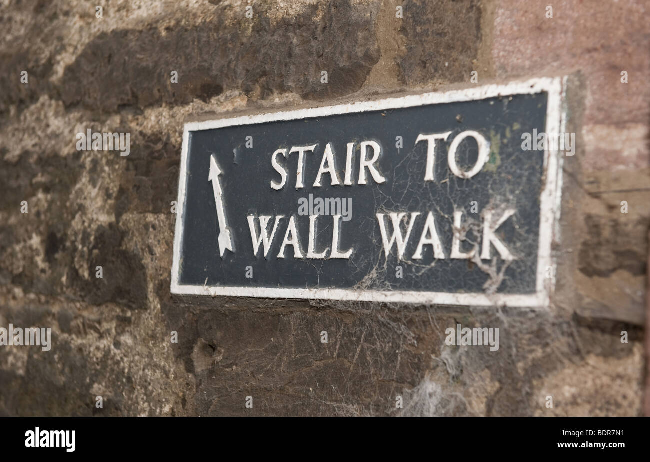 Cobweb covered "Stair to wall walk" cast iron sign attached to stone ...