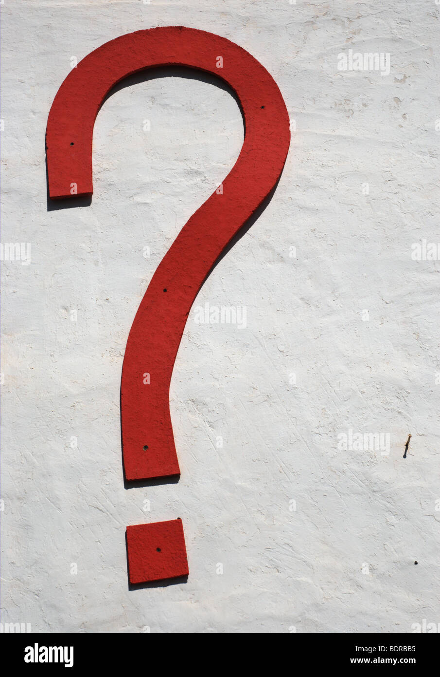 Big red question mark against a white wall Stock Photo - Alamy