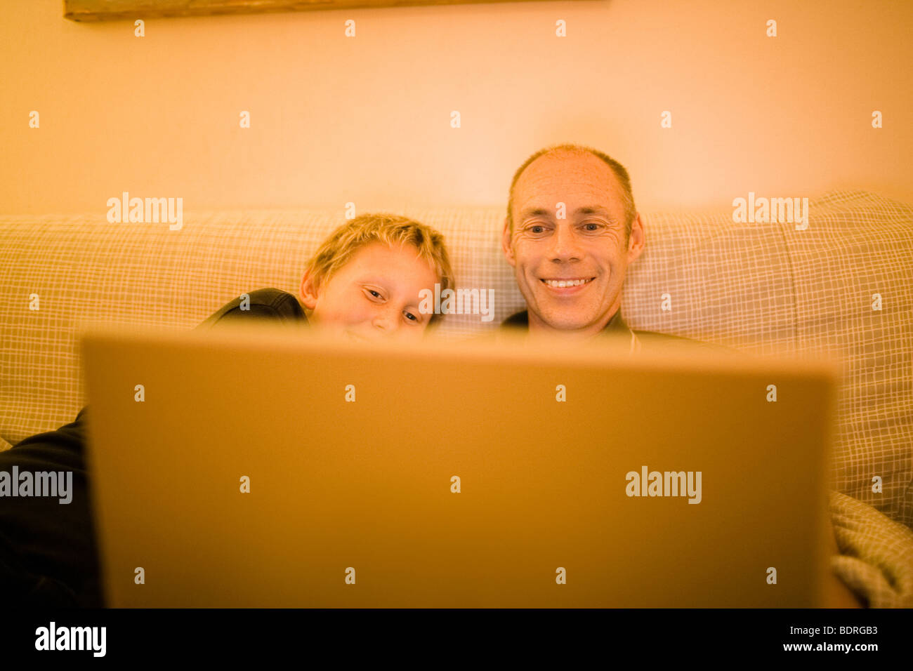 Parents and their children in front of a computer hi-res stock ...