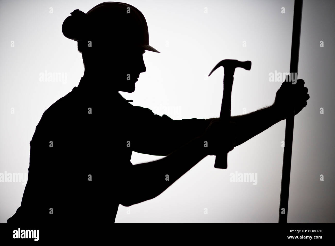 A construction worker using a hammer Stock Photo - Alamy
