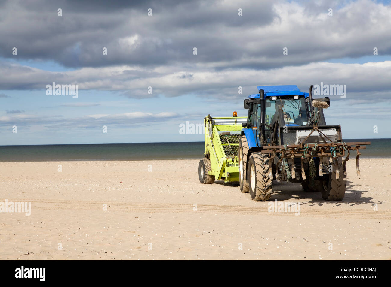 wheeled tractor for cleaning sand on beach Stock Photo - Alamy