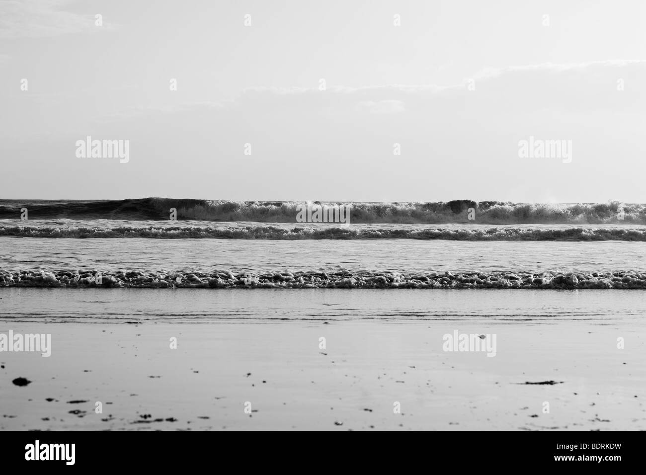 Medium sized waves crash on a beach during sunset Stock Photo - Alamy