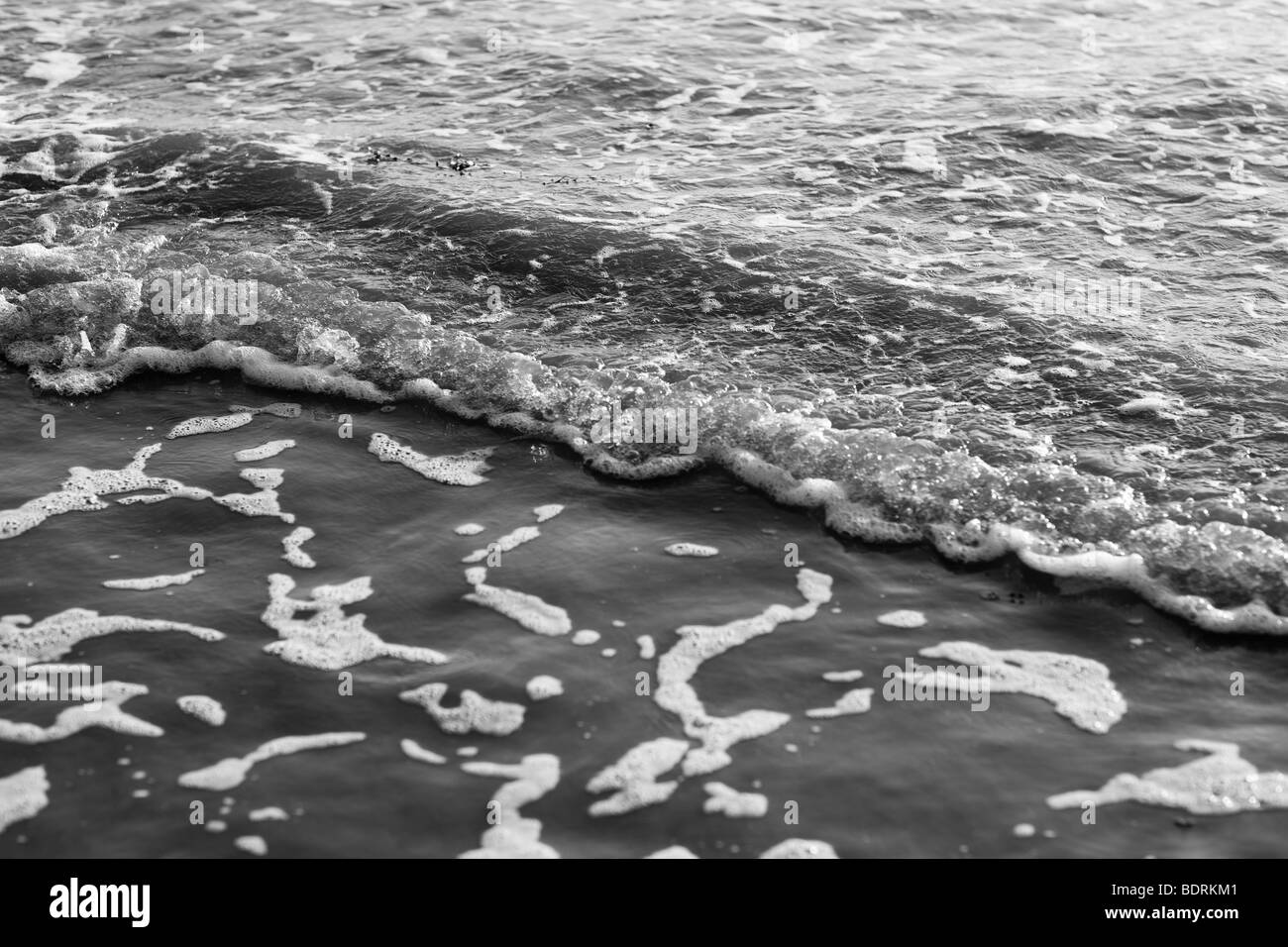 Medium sized waves crash on a beach during sunset Stock Photo - Alamy