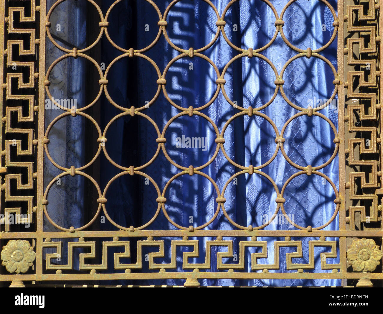 detail of blue curtains on window with rusted metal grill Stock Photo ...