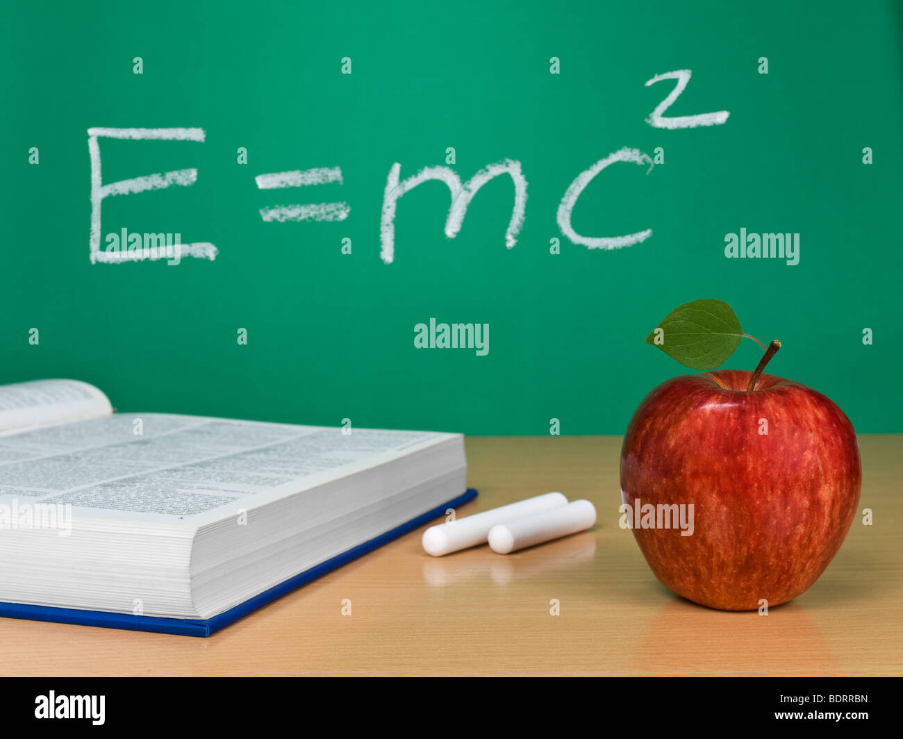 Einsteins formula of theory of relativity on a chalkboard. Books ...