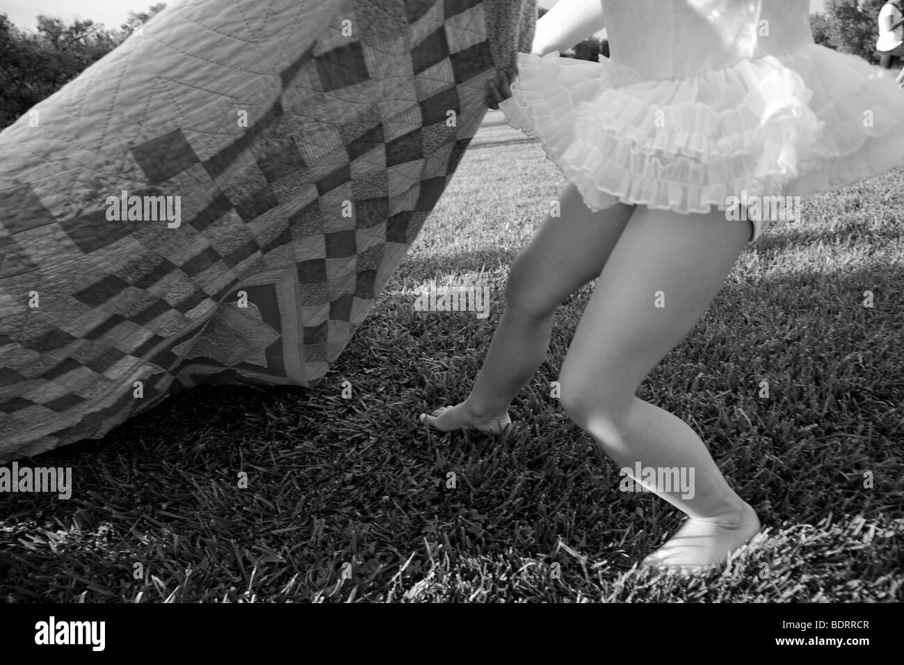 Black and white image of girl pulling blanket in park Stock Photo - Alamy