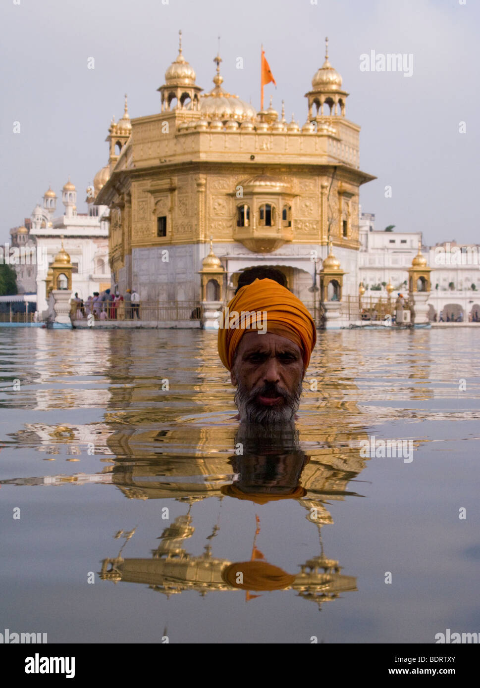 Sikh man bathes in the waters – the Sarovar (water tank) –around the ...