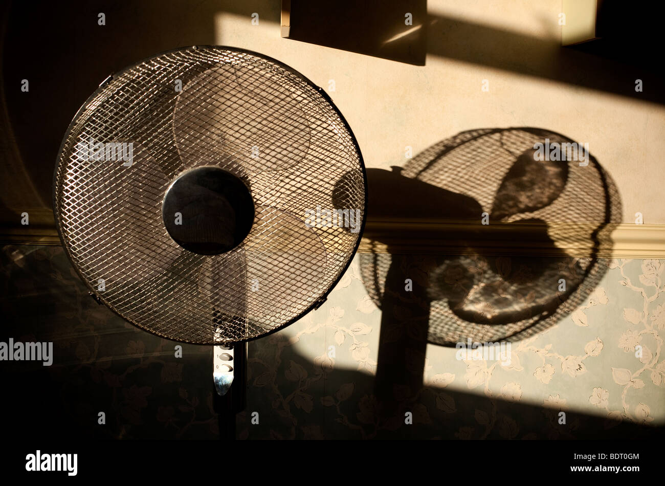 An electric fan casts a shadow on a wall Stock Photo - Alamy