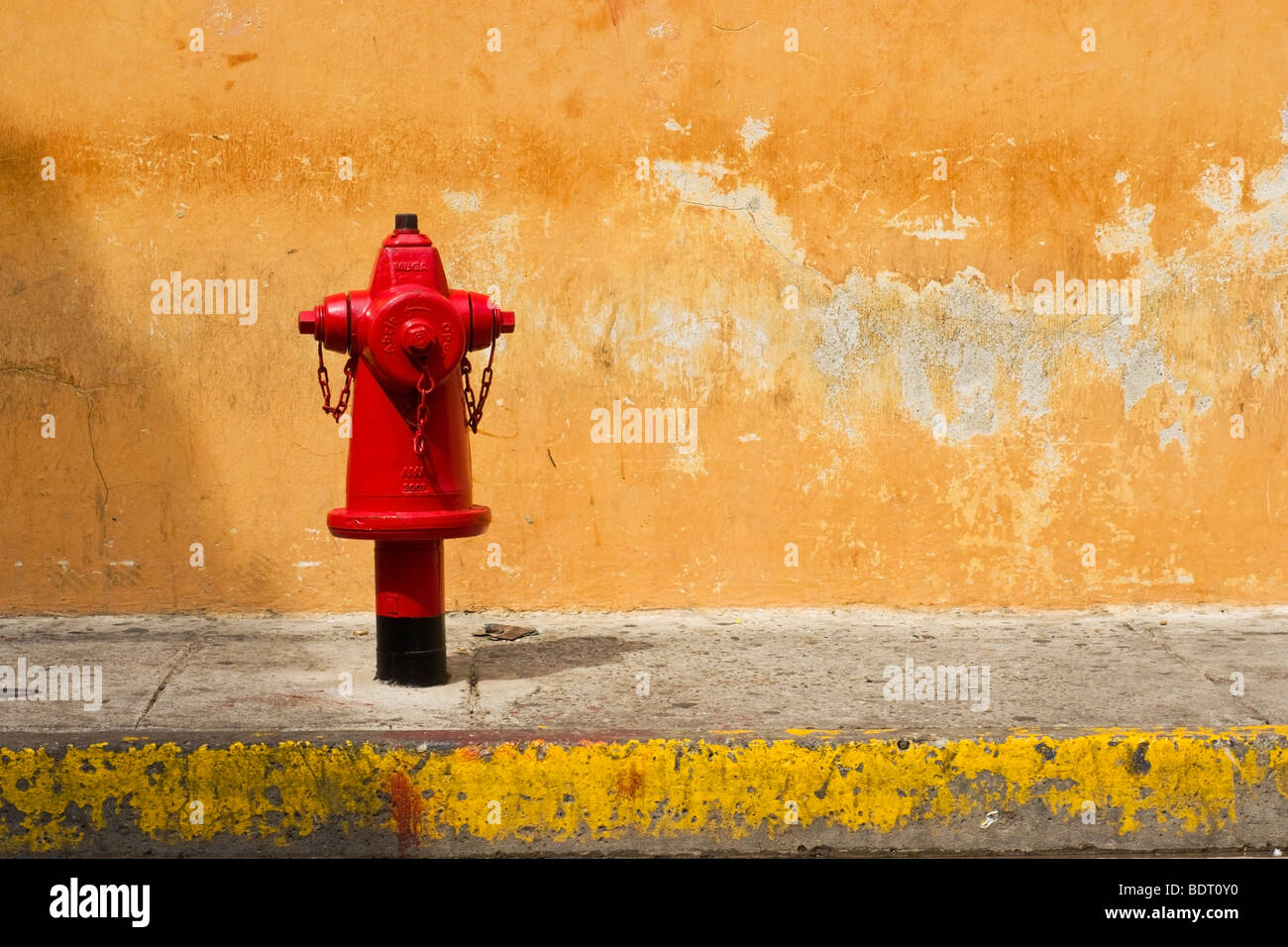 Red fire hydrant against old faded wall Stock Photo - Alamy