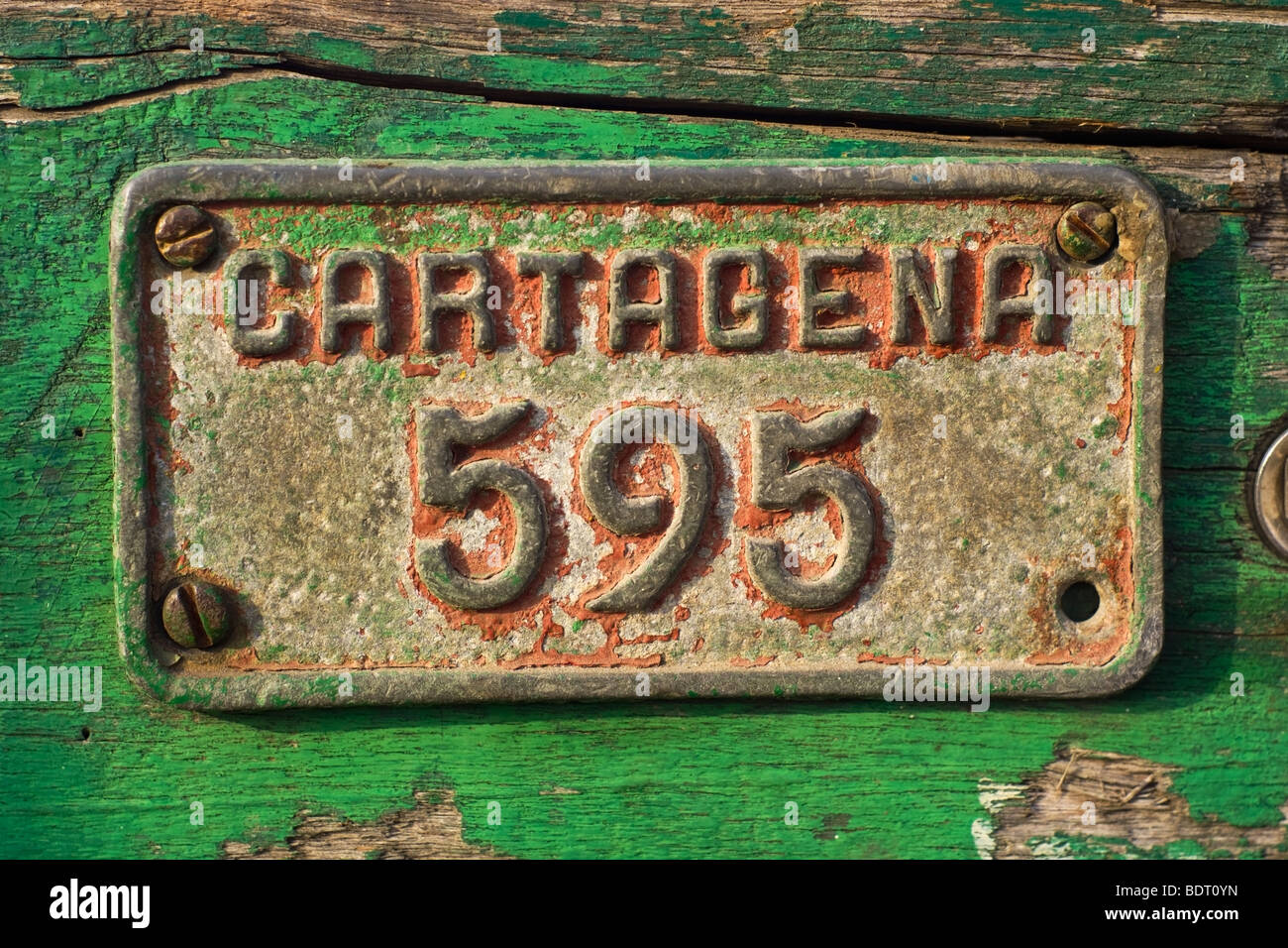 Licence plate with word" Cartagena 595" in old rusted letters against ...