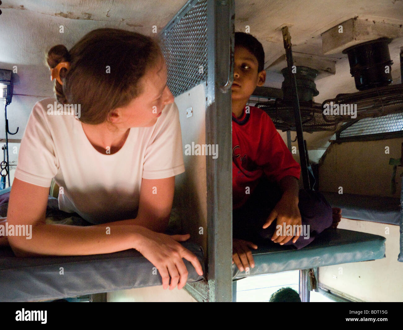 Western European passenger resting on a sleeper bed, & talking to a ...